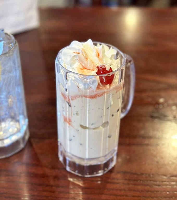 This towering malt looks like something from a 1950s soda fountain fever dream, cherry and all.
