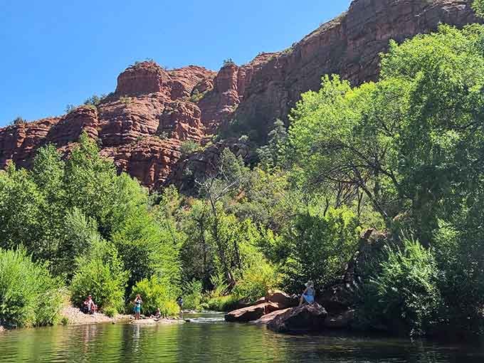 Lush trees provide shade along the water's edge, turning this desert oasis into something resembling a Bob Ross painting.