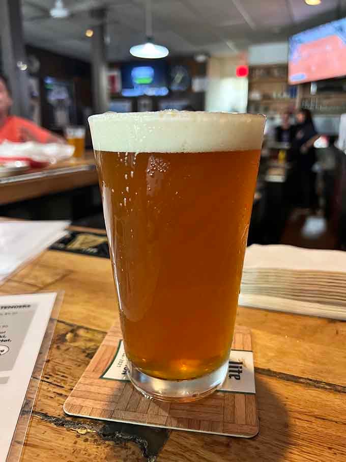 A perfectly poured cold one with that ideal foam crown, ready to wash down your wing adventure.