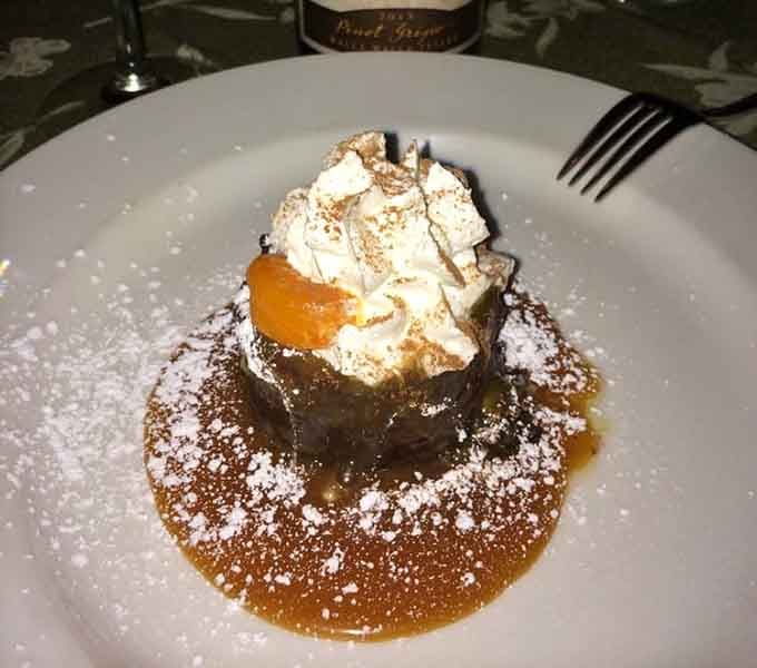 Bread pudding topped with whipped cream and caramel that'll make you reconsider your dessert-stomach capacity entirely.
