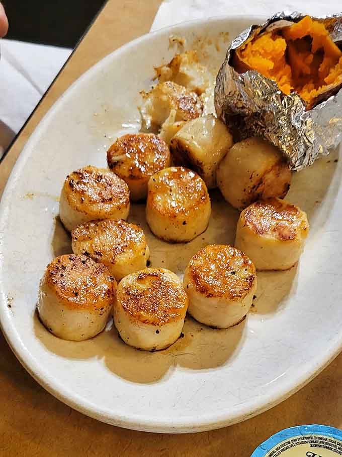 Perfectly seared scallops that would make Gordon Ramsay nod approvingly, baked potato included for good measure.