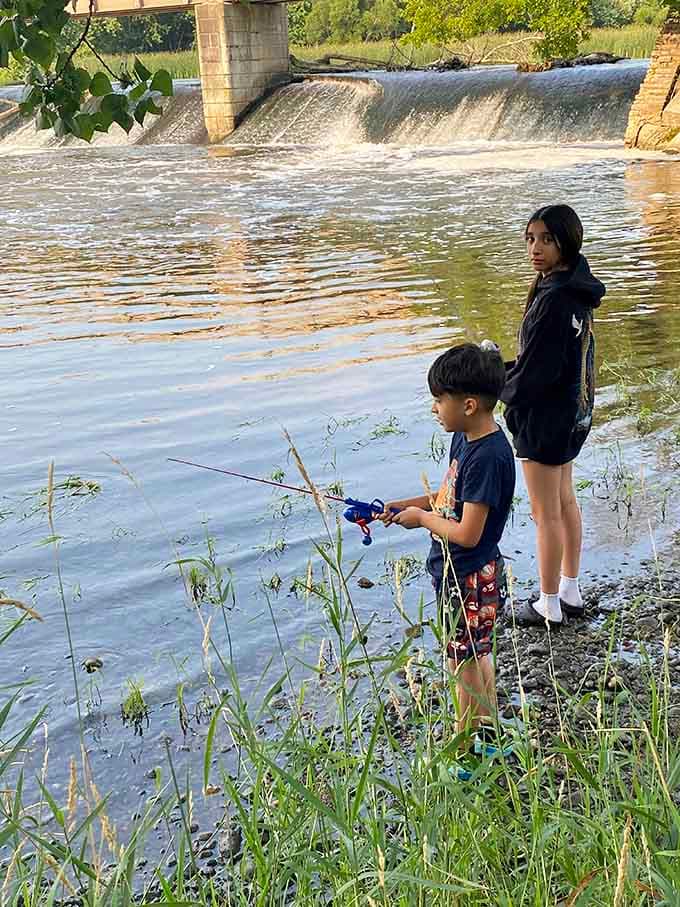 Young anglers testing their skills by the rushing water, creating memories that'll last longer than any video game.