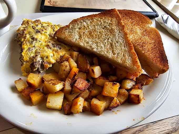 A fluffy omelet packed with sausage and peppers alongside crispy home fries makes mornings worth waking for.