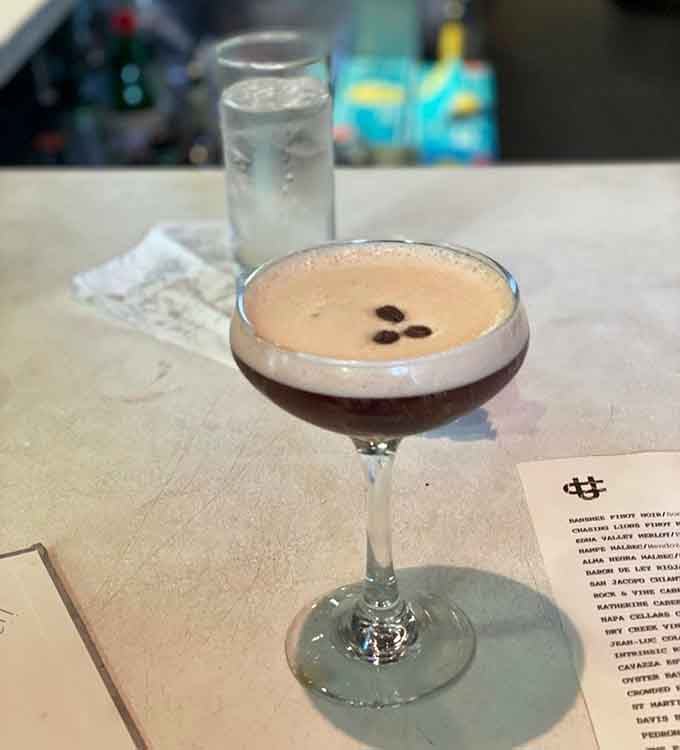 An espresso martini with three coffee beans floating on top, the kind of pick-me-up that feels both sophisticated and necessary.