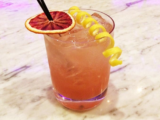 The Ciao Bella cocktail arrives looking like a sunset in a glass, complete with citrus garnish for maximum sophistication.