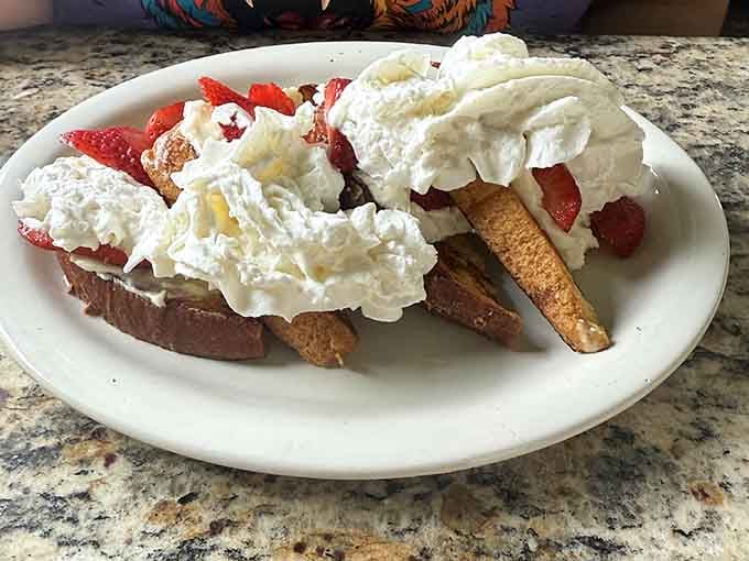 Strawberry-topped French toast buried under whipped cream answers the question: can breakfast be dessert? Absolutely yes.