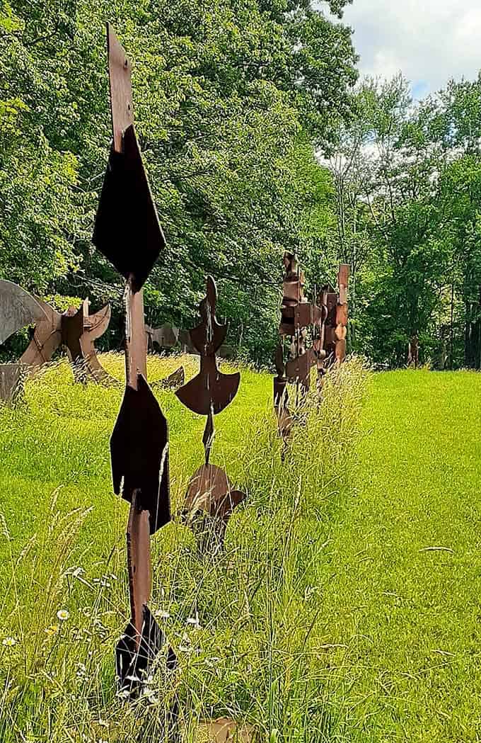 A family of steel totems rises from the grass like metallic sentries guarding secrets only the sculptures know.