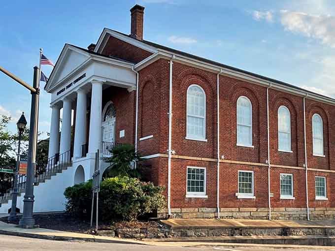 The courthouse stands proud in brick and white columns, a testament to Southern architecture done absolutely right.