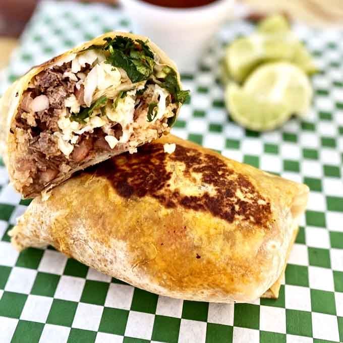 That birria burrito is stuffed so full, it looks like it's about to stage a delicious rebellion.