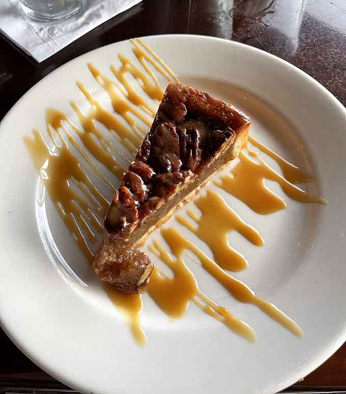 Bourbon pecan pie drizzled with caramel sauce, because every great seafood meal deserves a sweet Southern finale.