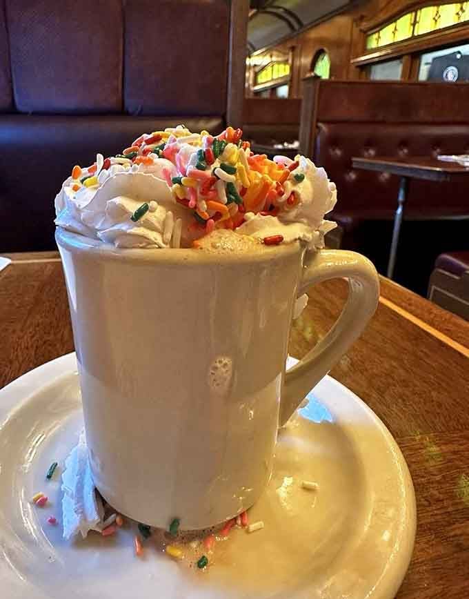 Hot chocolate piled high with whipped cream and sprinkles, making your inner child very, very happy right now.
