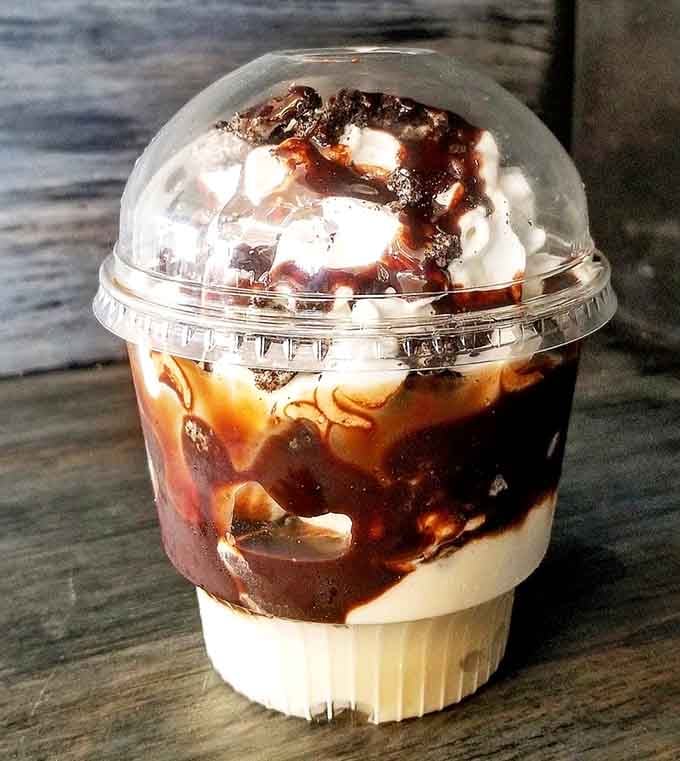 The Oreo sundae towers like a dessert skyscraper, whipped cream threatening to defy gravity entirely.