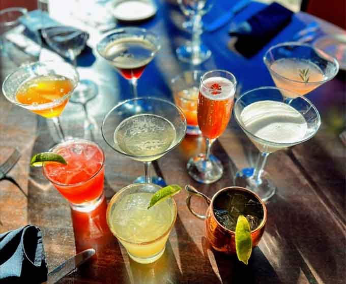 A rainbow of handcrafted cocktails that look almost too pretty to drink, but you'll manage to power through somehow.