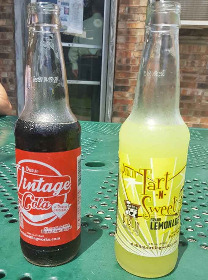 Vintage cola and tart lemonade in glass bottles on a green table feels like summer in 1975.