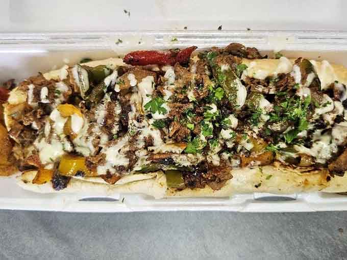 That steak philly stretches the full length of its container, loaded with peppers and melted goodness.