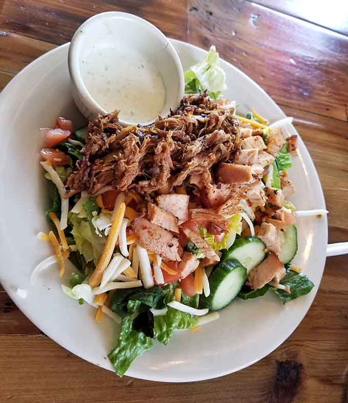 A mountain of pulled pork and brisket on fresh greens proves that salad can absolutely be a main event.