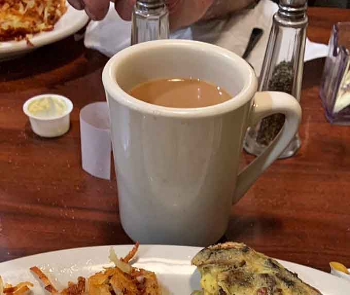 Hot coffee in a proper mug, the kind that gets refilled before you even ask for it.