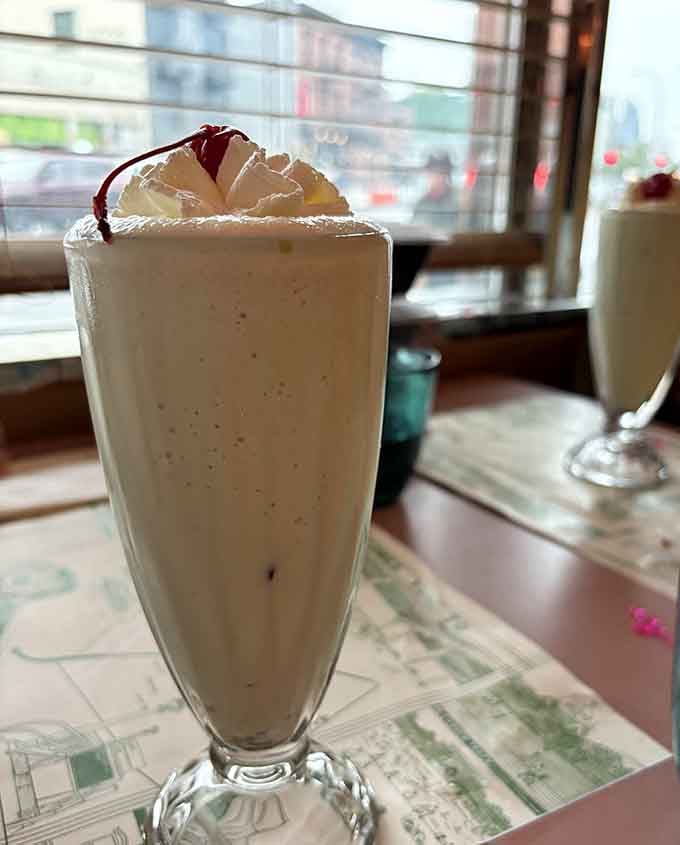 A milkshake so thick the straw stands at attention, topped with whipped cream and a cherry for good measure.