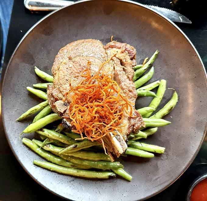 These pork chops get the royal treatment with asparagus and crispy garnish, proving this kitchen doesn't play favorites with proteins.