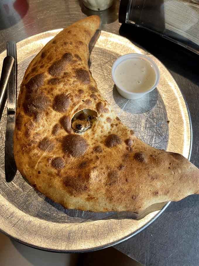 This calzone looks like a crescent moon that fell from the sky and landed perfectly on your plate.