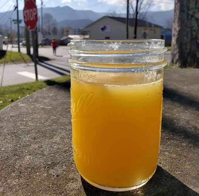 Fresh orange juice in a mason jar with mountain views, because even your beverages deserve a scenic breakfast experience.
