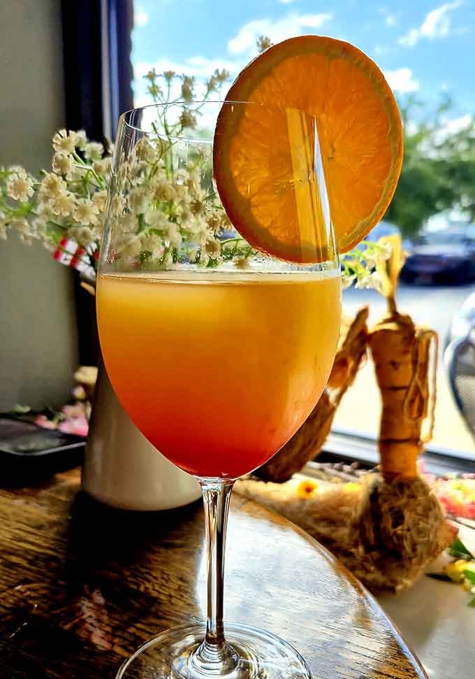 A mimosa garnished with an orange slice brings a touch of brunch elegance to your enchanted forest experience.
