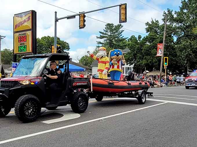 Sparky the Fire Dog waves from his boat, teaching fire safety while looking absolutely thrilled to be part of the festivities.