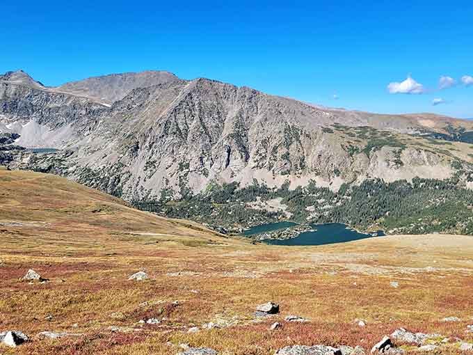Alpine tundra stretches toward a glacial lake cradled by ancient peaks, rewarding hikers with views worth every uphill step.