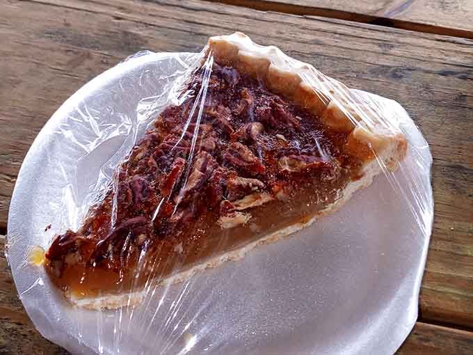 Pecan pie under plastic wrap waiting to complete your barbecue feast with Southern sweetness and nutty perfection perfectly balanced.
