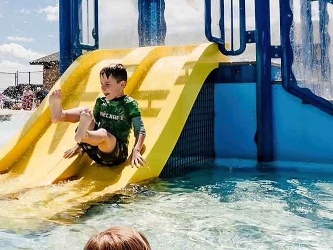 Pure joy captured mid-slide, proving that happiness really does come in yellow tube form here.