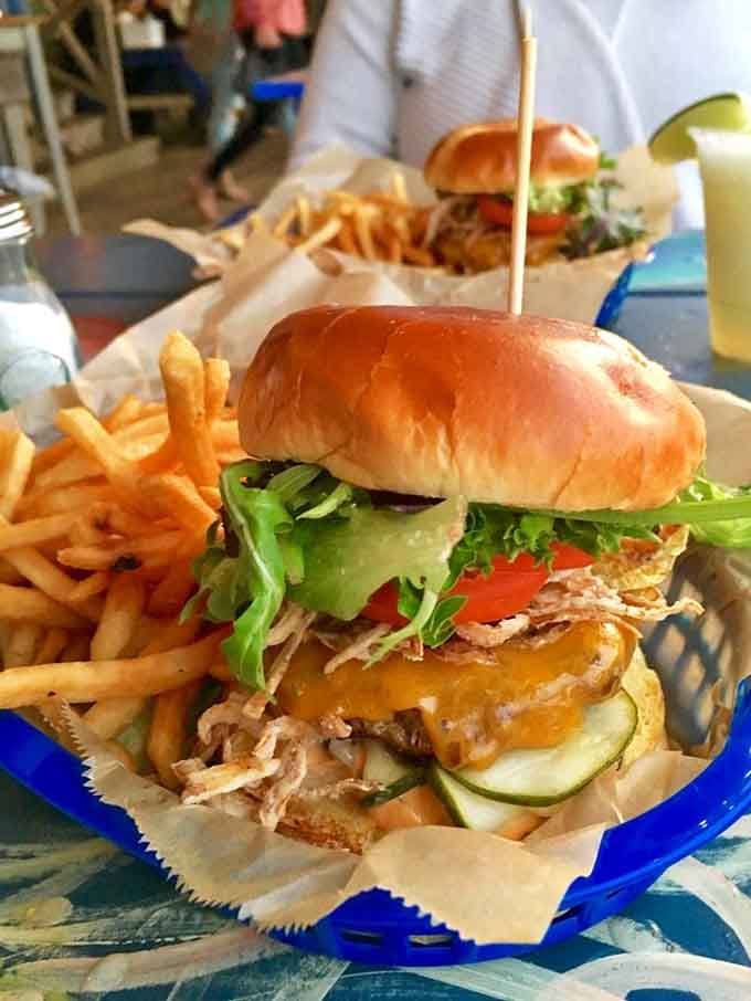 This burger situation comes with enough toppings to require architectural planning before your first bite, worth every delicious moment.