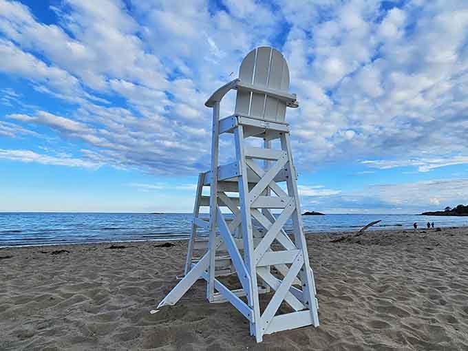 The classic white lifeguard chair stands sentinel, a reassuring presence against the endless blue summer sky.