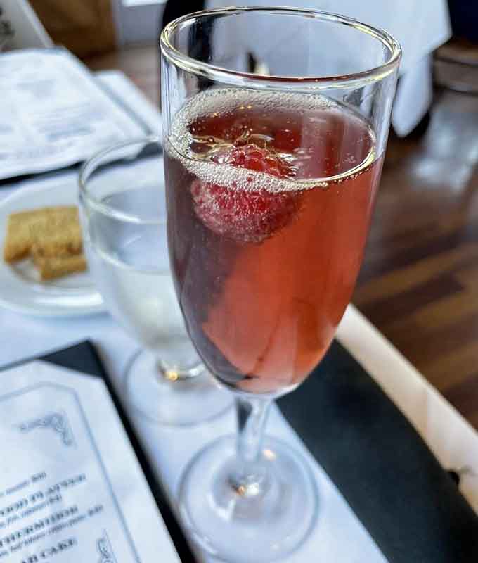 A mimosa dressed up with fresh berries, because even brunch cocktails deserve a little extra love and attention here.