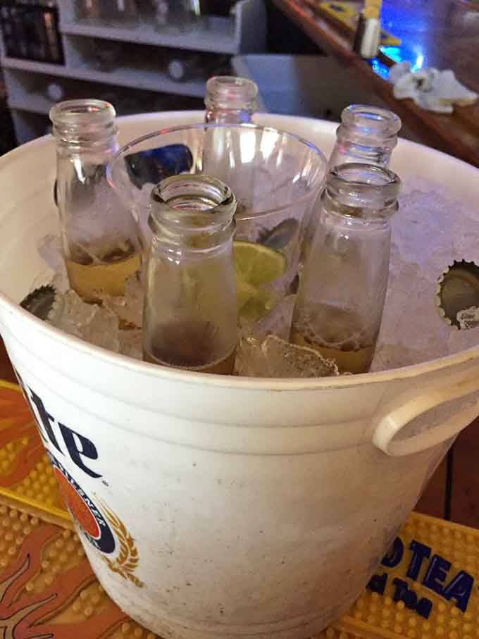 Beer bucket on ice with lime wedges waiting, because proper hydration is important when you're cracking crab in paradise.