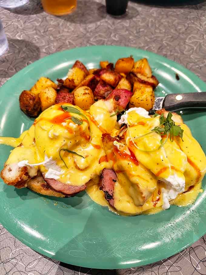 Eggs Benedict gets the royal treatment here, draped in hollandaise that flows like liquid gold over everything.