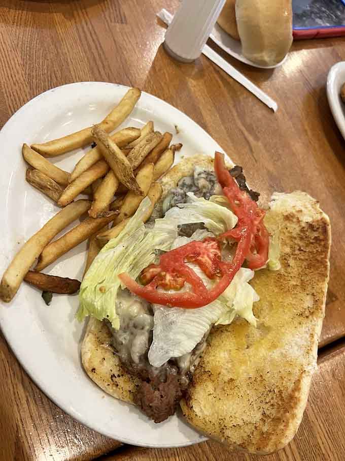A Philly cheesesteak so loaded it practically needs its own zip code, served alongside perfectly seasoned hand-cut fries.