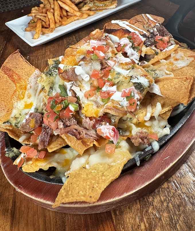 Nachos piled so high with toppings, you'll need an engineering degree to figure out where to start eating them first.