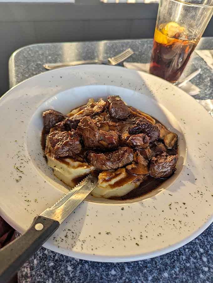Tender beef tips nestled on garlic mashed potatoes with mushroom demi-glace, the kind of comfort food that makes you sigh contentedly.