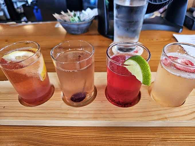 Four colorful cocktails lined up like they're about to perform a synchronized swimming routine for your taste buds.