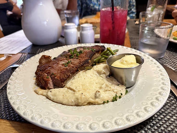 A perfectly cooked ribeye with creamy grits proves this place does way more than just pizza, and does it exceptionally well.