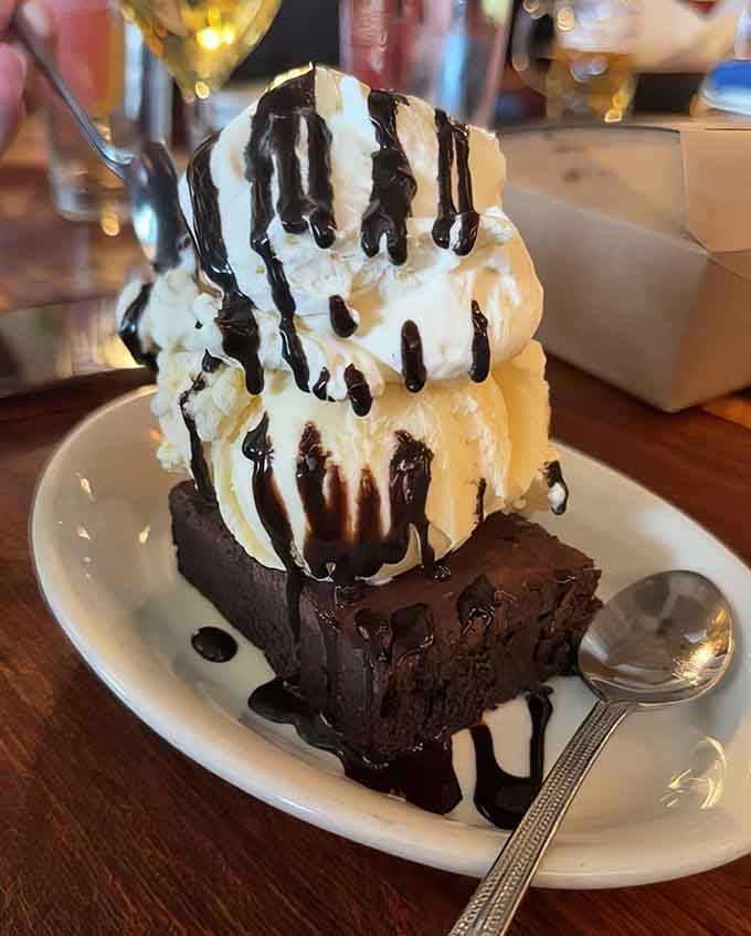 This brownie sundae defies gravity and common sense, towering like a delicious monument to pure indulgence.