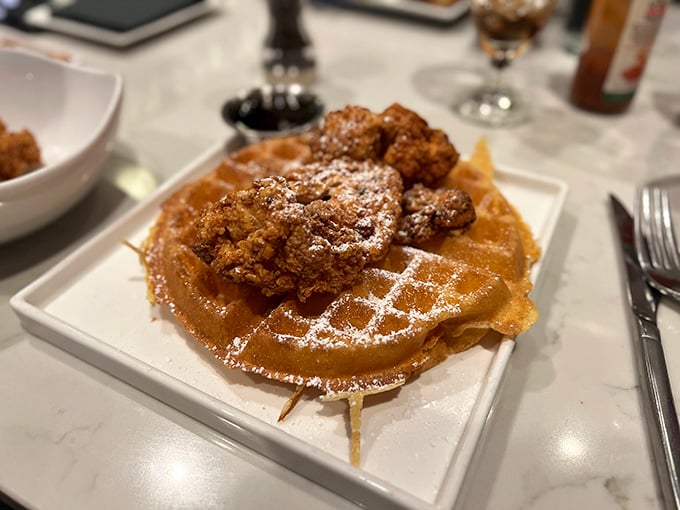 Chicken and waffles that unite sweet and savory in perfect harmony, dusted with powdered sugar dreams.