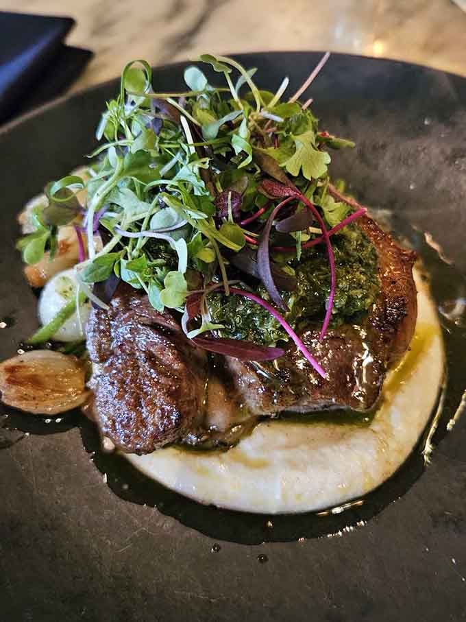 Tender lamb topped with microgreens over creamy polenta is the kind of dish that makes you sit up straighter automatically.
