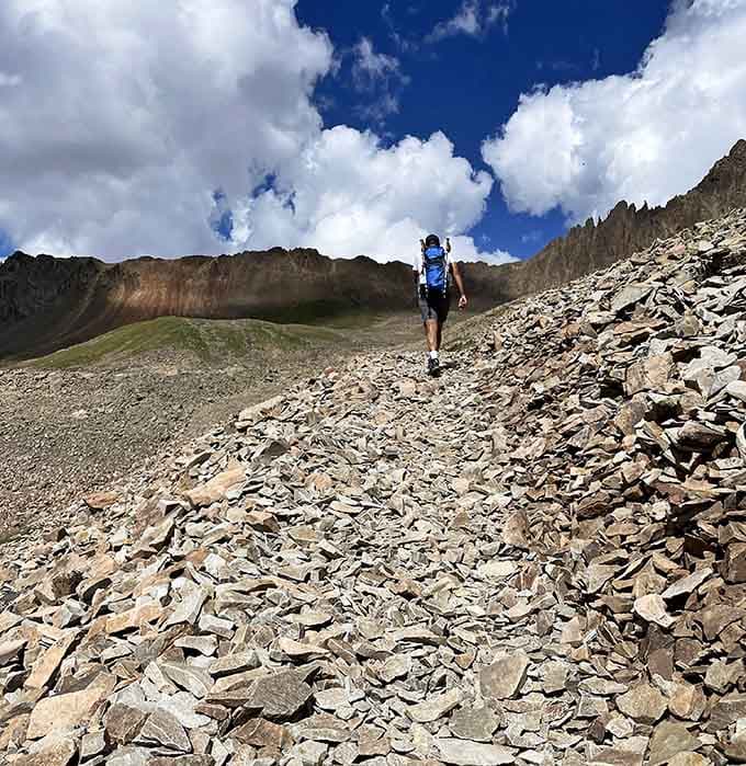Solo hikers traverse rocky paths where every step brings new perspectives on Colorado's dramatic landscape.