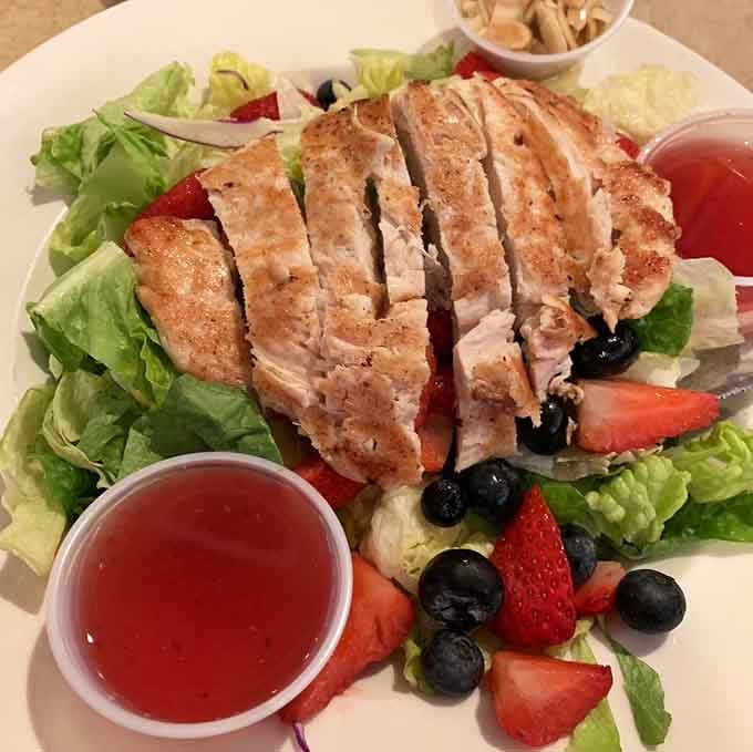 Grilled chicken sliced over fresh greens with berries makes eating healthy feel like a treat.