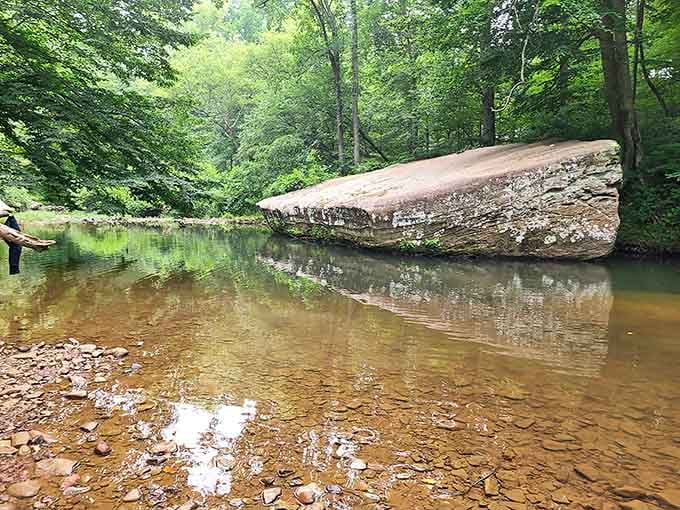 That massive boulder balances impossibly over crystal-clear shallows, creating shade and wonder in equal generous measures throughout.