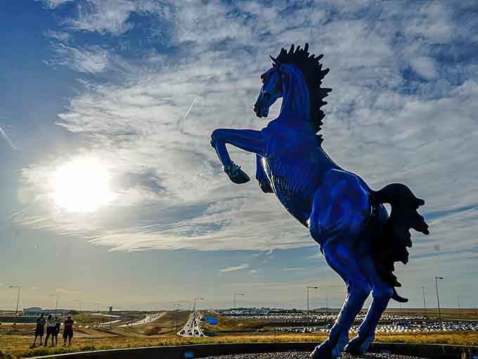 That electric blue stallion rears up against the sunset, greeting travelers with glowing red eyes that spark endless debate.