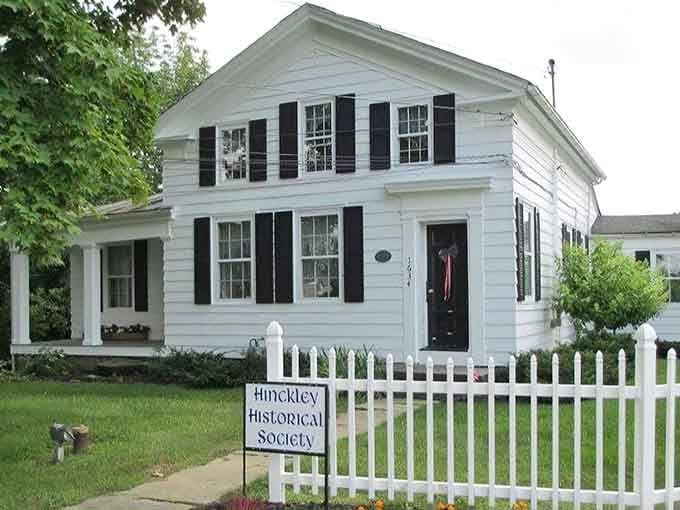 The white picket fence and historical society sign welcome visitors to discover stories preserved with love and care.