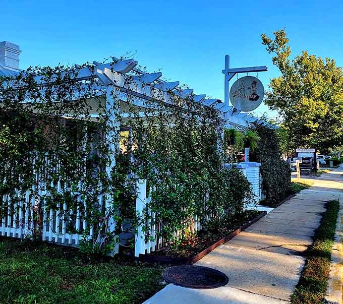 Lush greenery and a white picket fence surround this French bakery where the aroma of fresh croissants drifts through the air.
