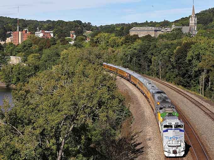 A freight train curves through the valley like a mechanical snake, connecting this town to the world.